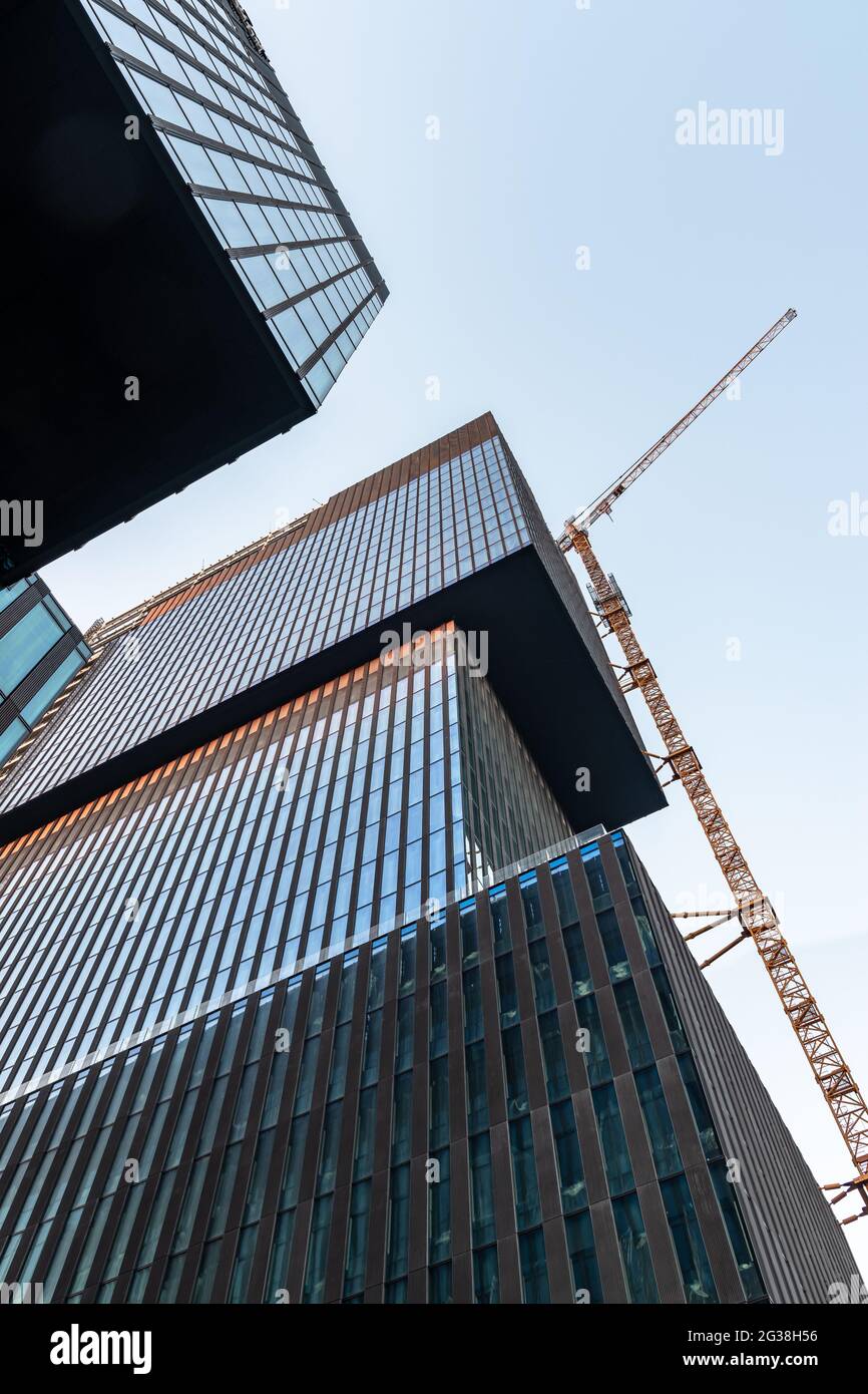 Skyscraper under construction and construction crane viewed from below ...