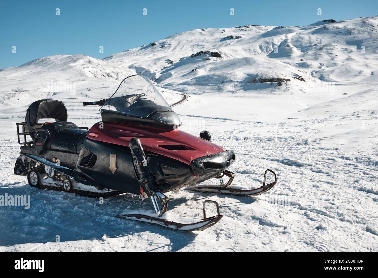 Snowmobile against snow covered slope at background Stock Photo - Alamy