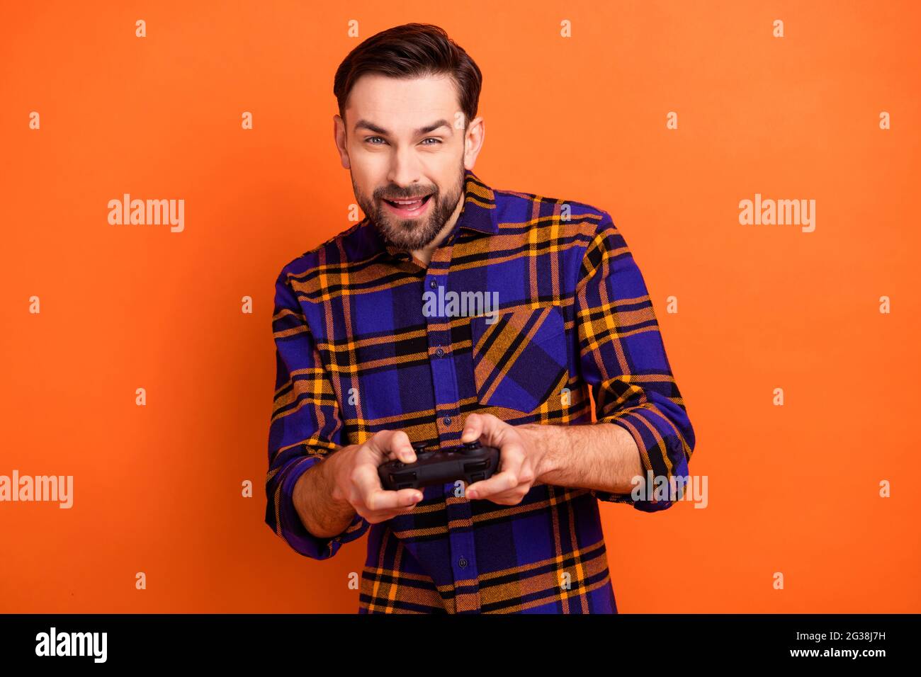 Portrait of excited young man playing games look interested camera wear ...