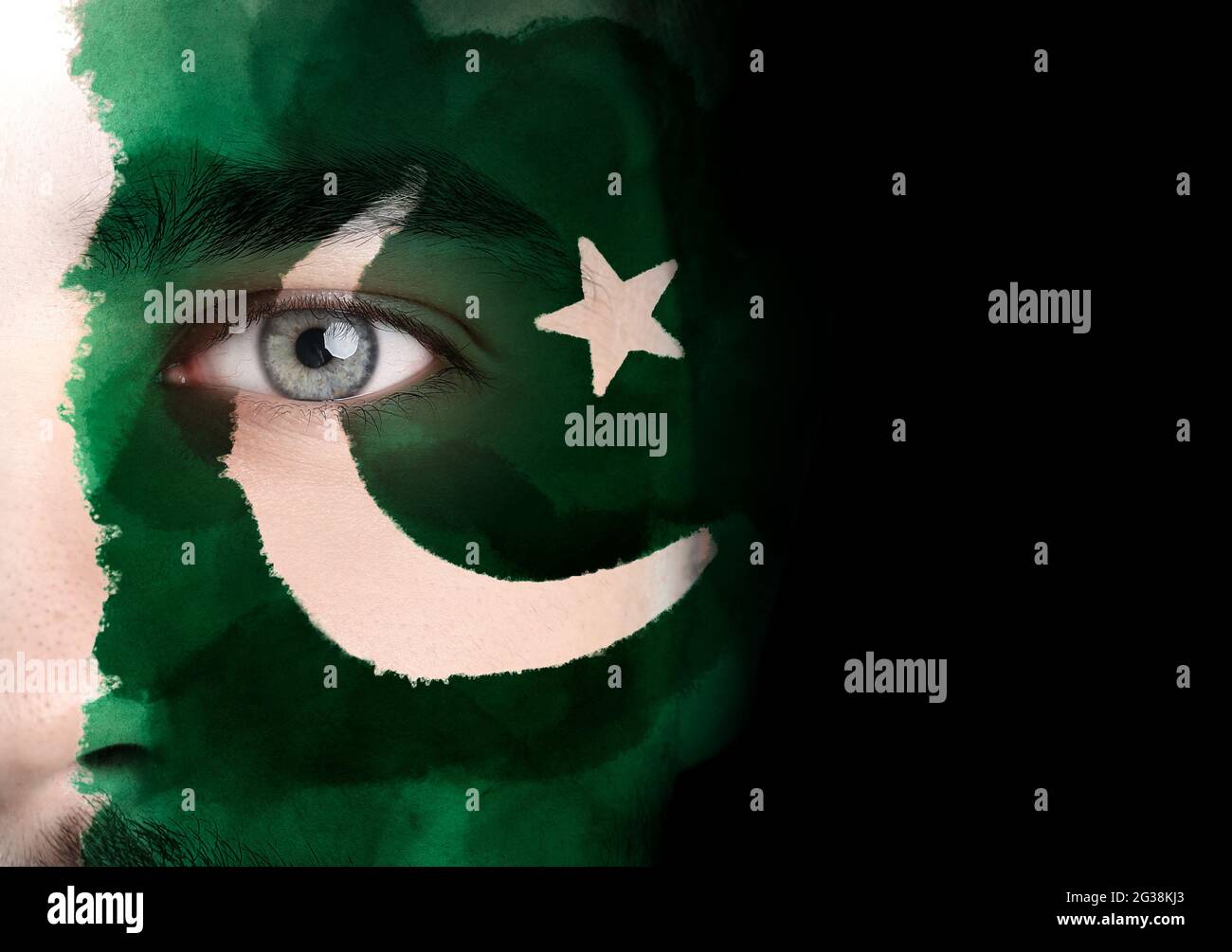 Young man with face in colors of Pakistan flag on dark background ...
