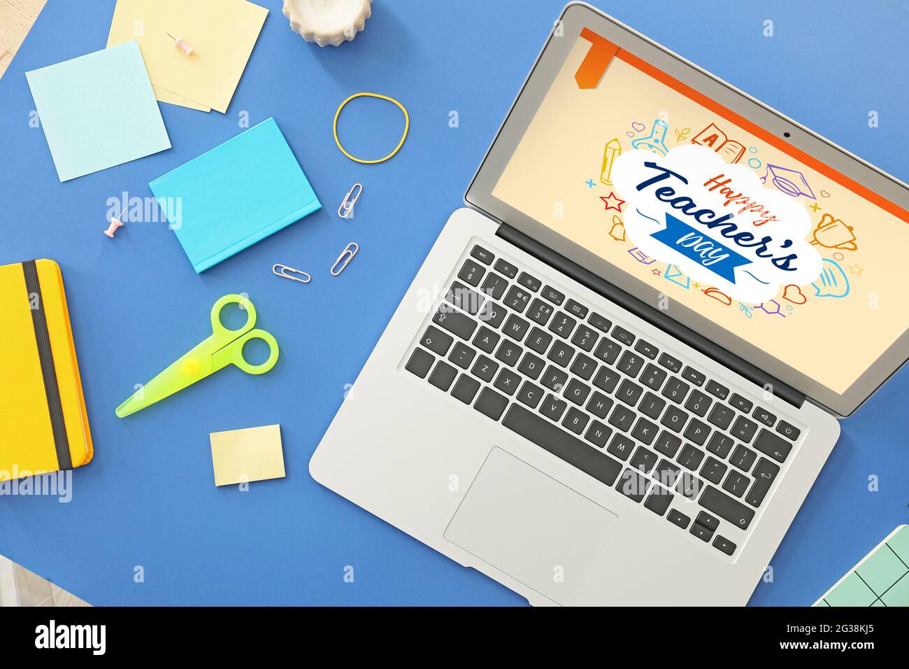 Text HAPPY TEACHER'S DAY on screen of laptop and stationery on color ...