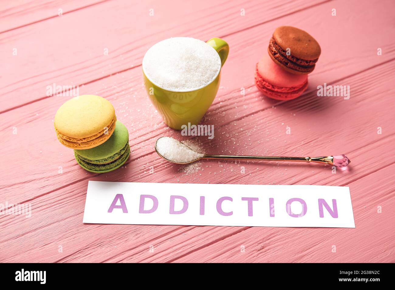 Word ADDICTION, cup with sugar and cakes on color wooden background ...