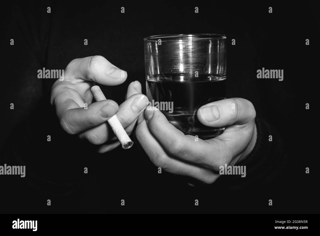 Hands with cigarette and alcohol on dark background. Concept of ...