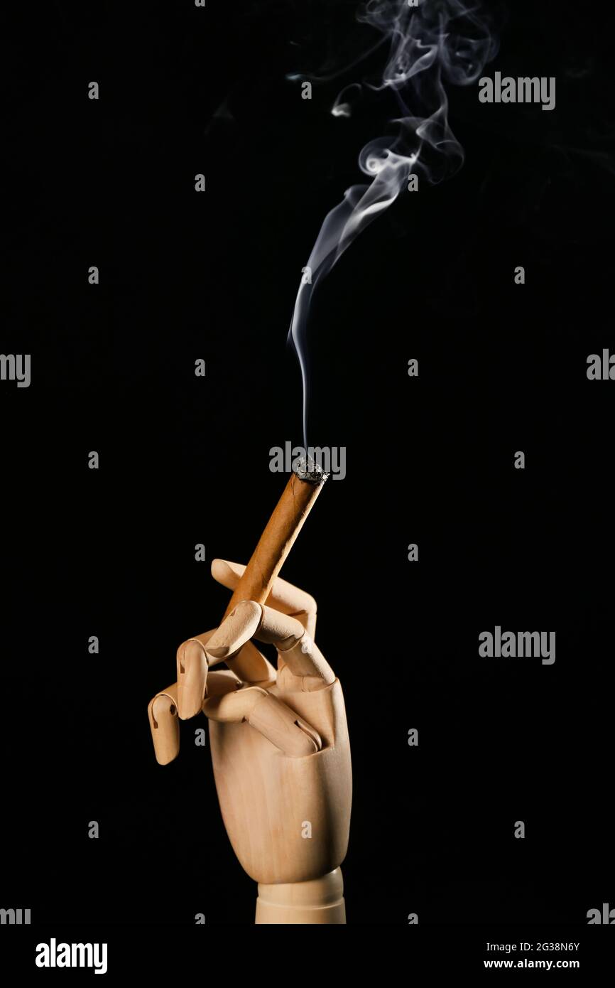 Wooden hand with cigar on dark background. Concept of addiction Stock ...