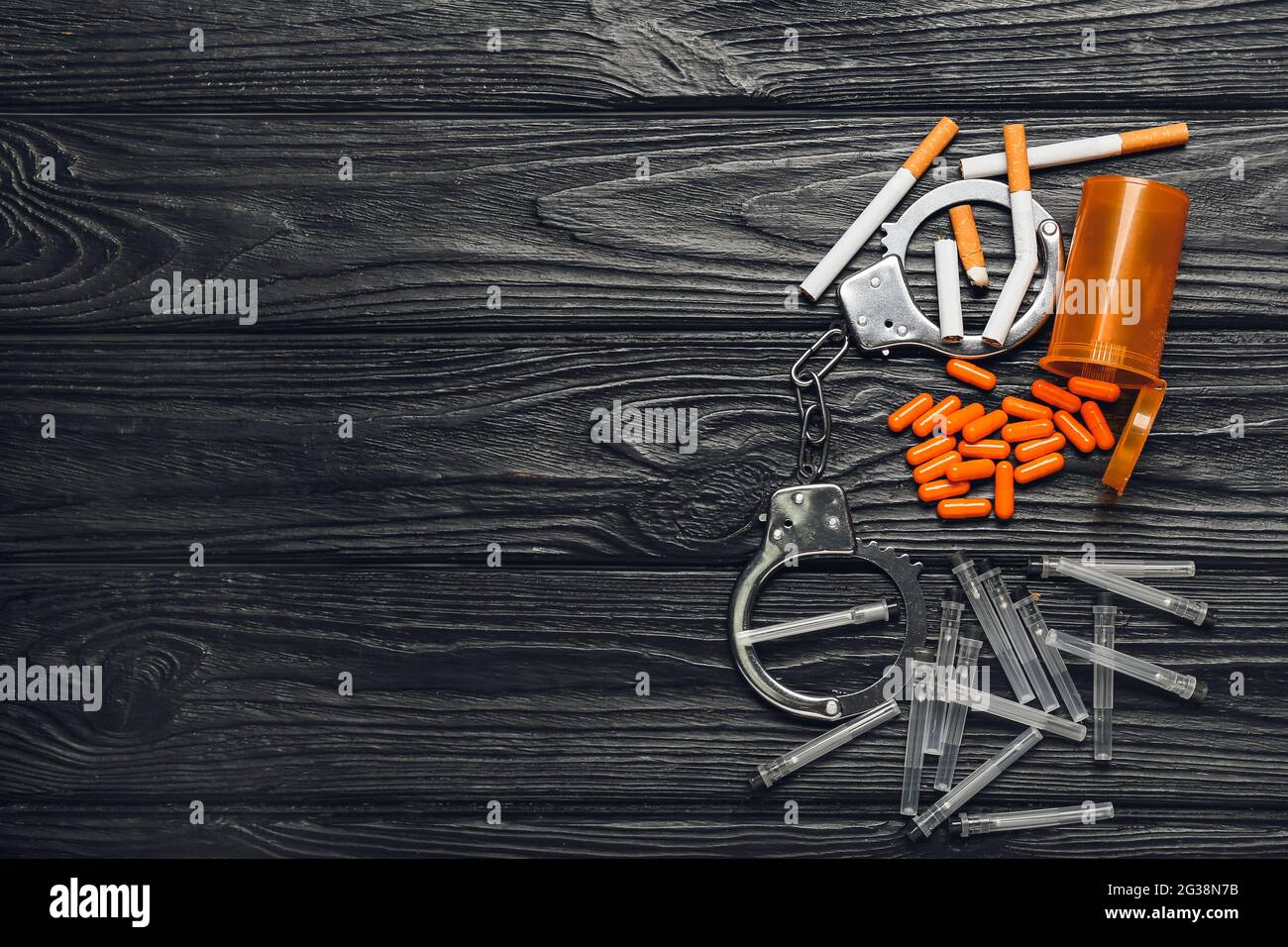 Handcuffs, drugs and cigarettes on wooden background. Concept of ...