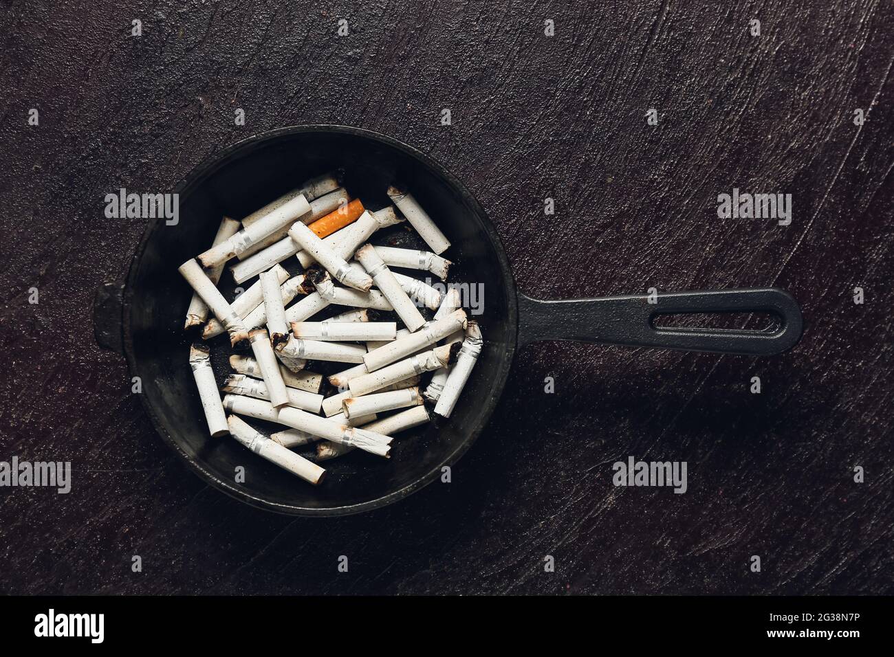 Frying pan with many cigarettes on dark background. Concept of ...