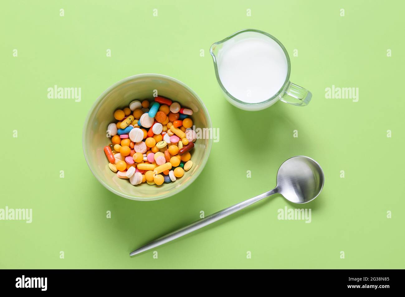 Bowl with pills and jug of milk on color background. Concept of ...