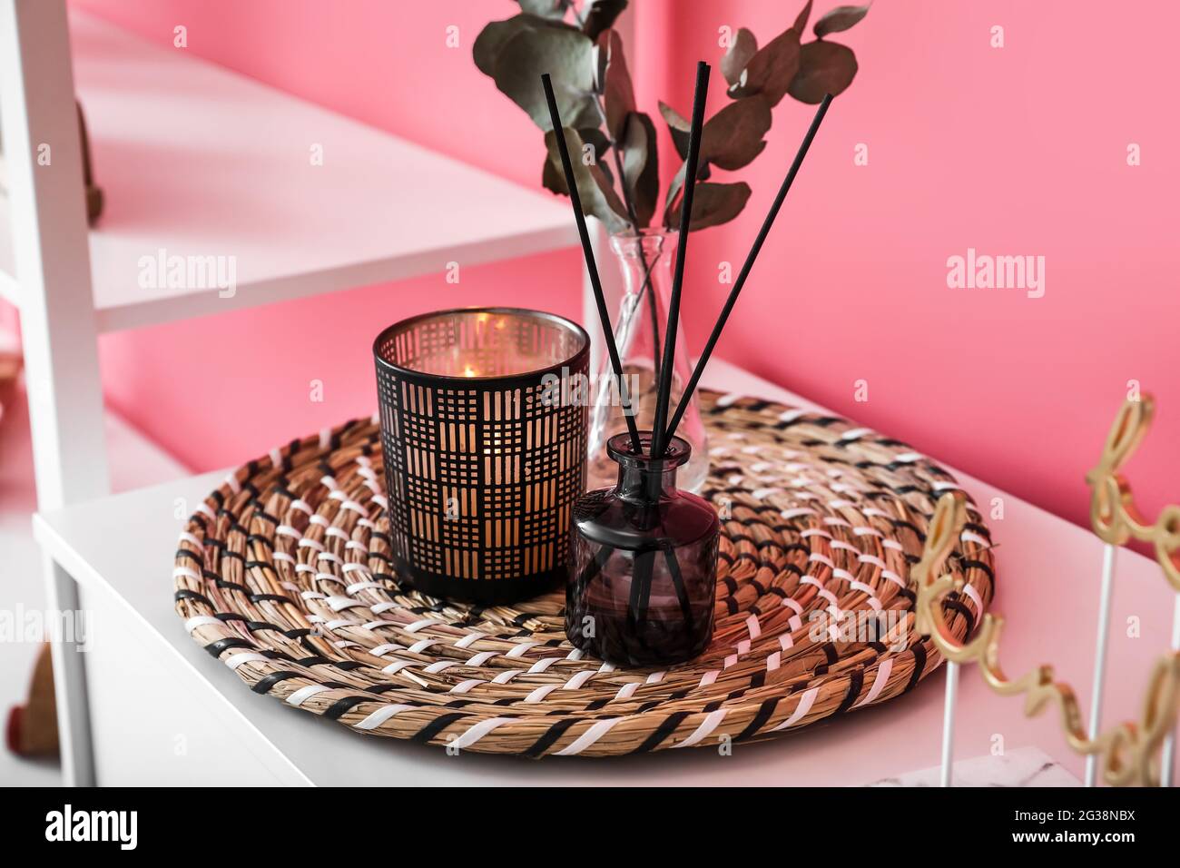 Reed diffuser with candle and vase on shelf near color wall Stock Photo ...