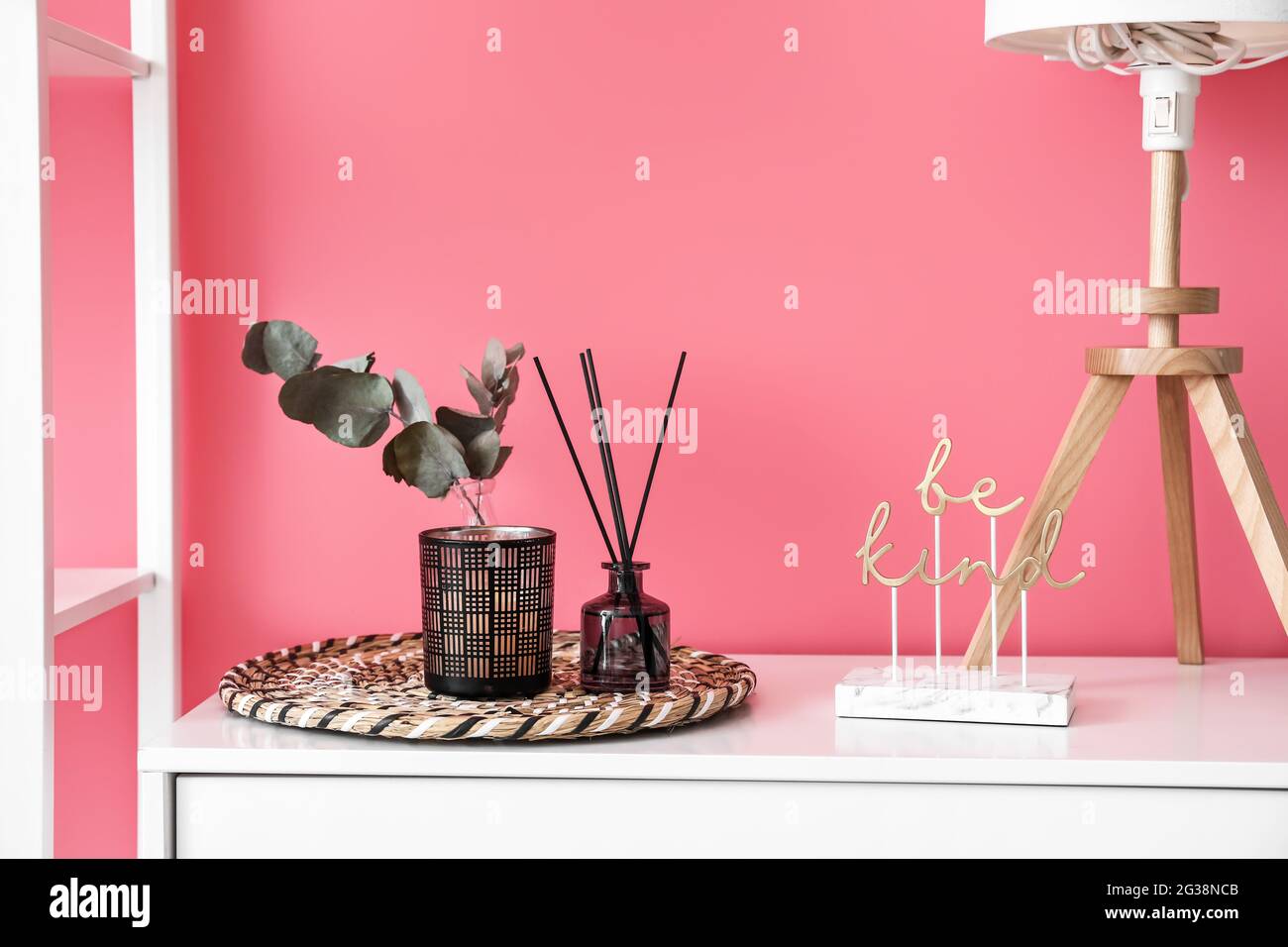 Reed diffuser with candle on shelf near color wall Stock Photo - Alamy