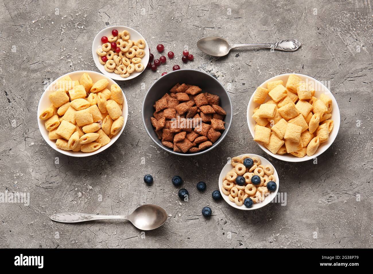 Different cereals and berries on grey background Stock Photo - Alamy