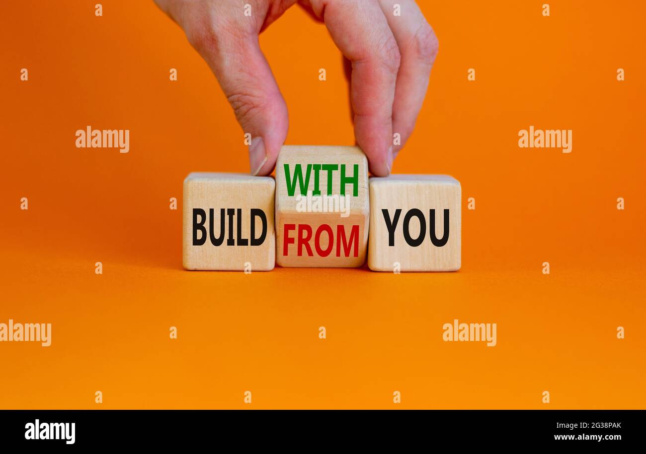 Build from or with you symbol. Businessman turns wooden cubes and ...