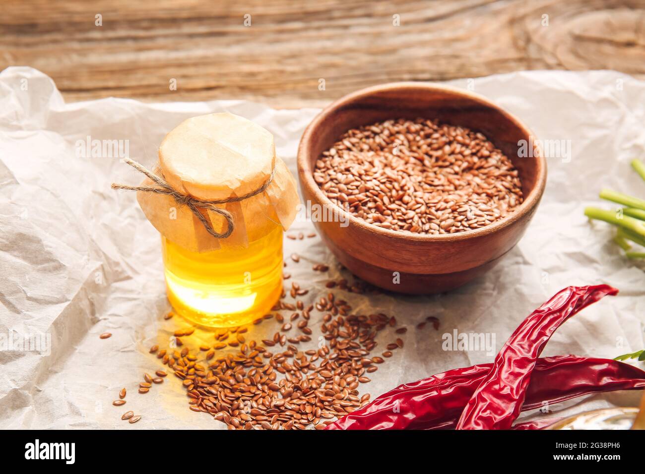 Bowl with flax seeds, oil and chili peppers on wooden background Stock ...