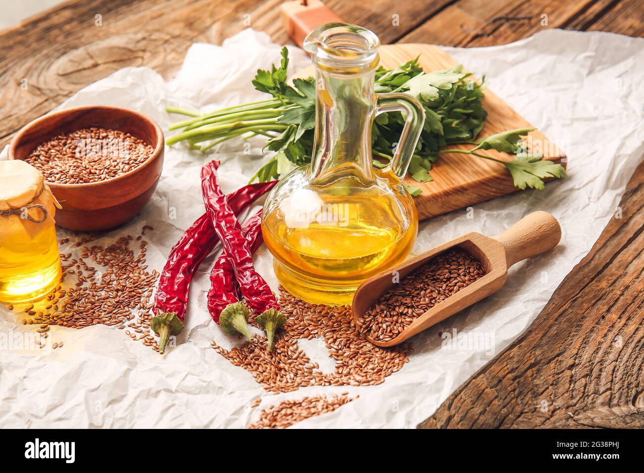 Composition with flax oil, seeds, chili peppers and parsley on wooden ...