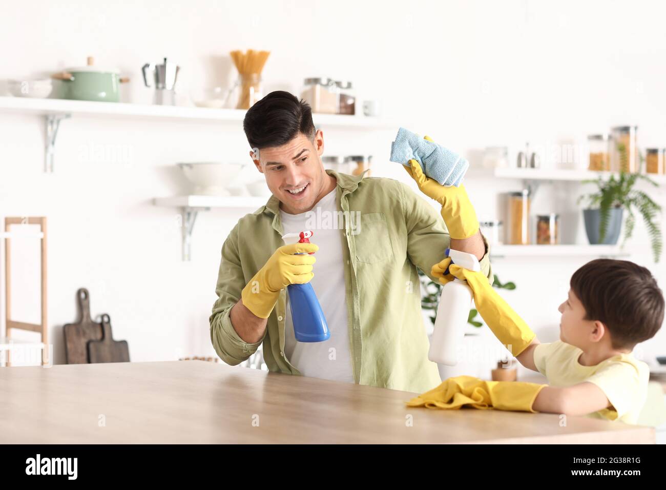 Father and son having fun while cleaning table in kitchen Stock Photo ...