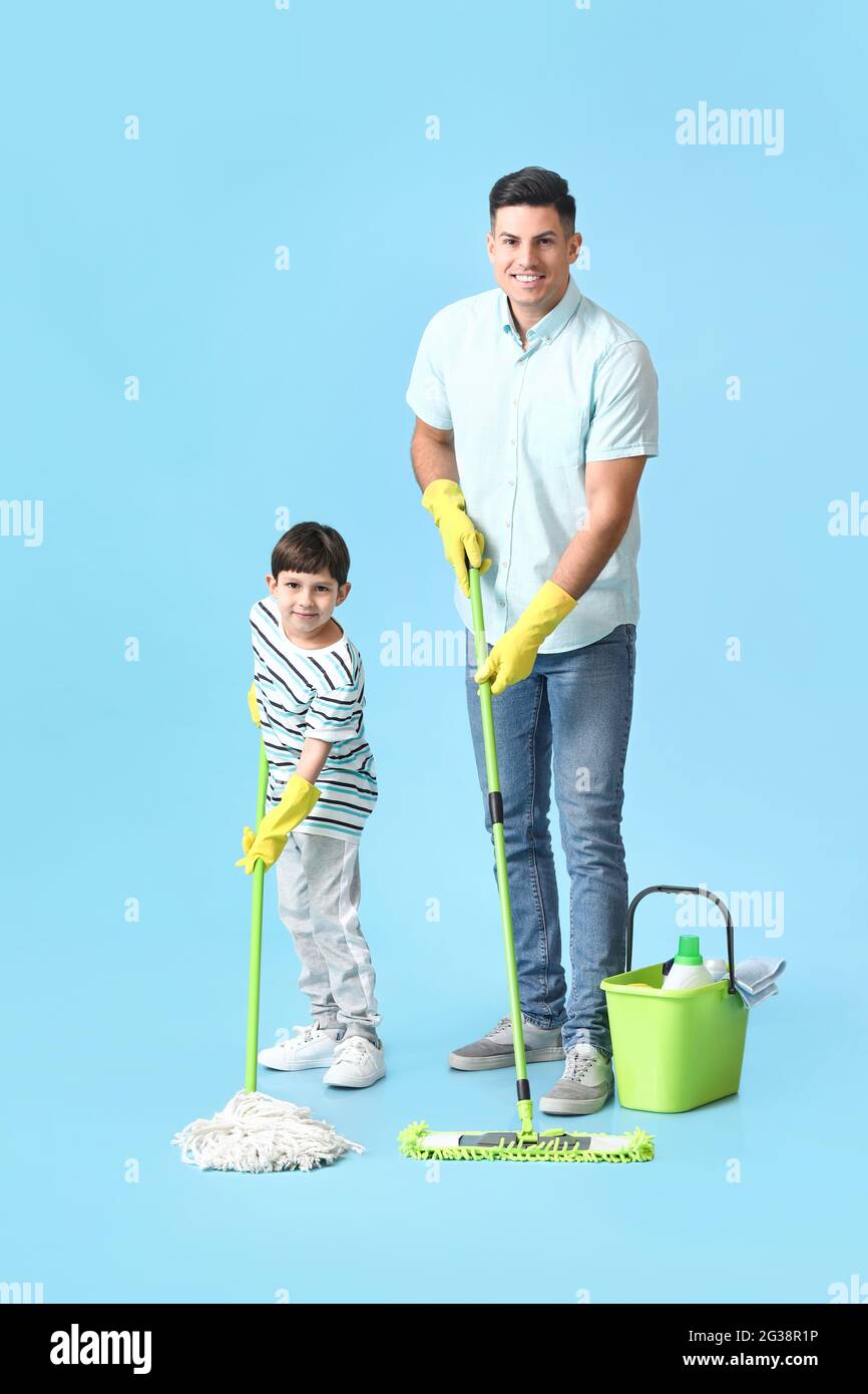 Father and son mopping floor on color background Stock Photo - Alamy
