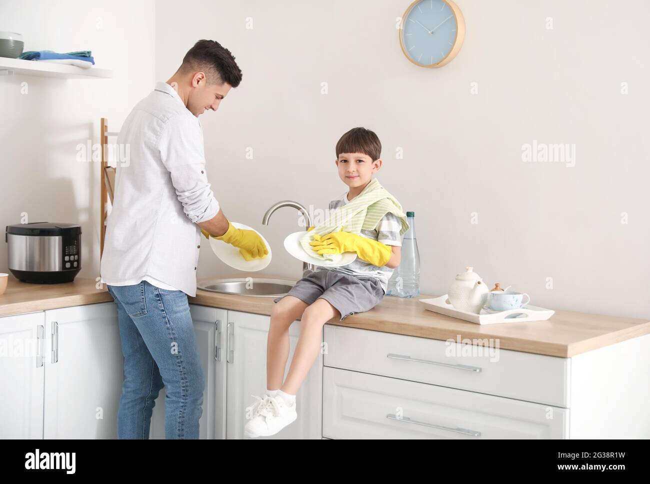 Father and son washing dishes in kitchen Stock Photo - Alamy