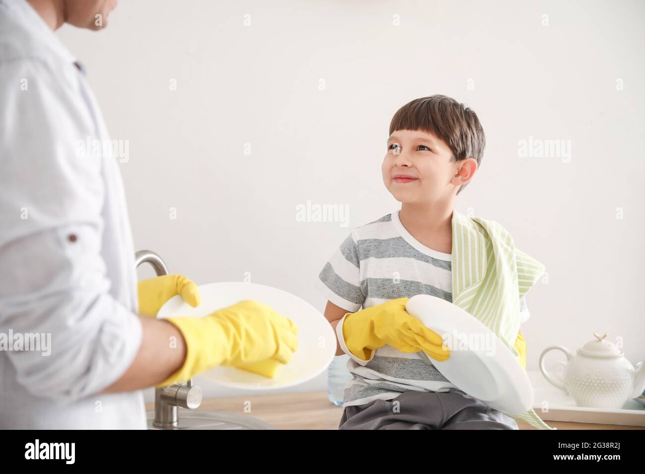 Father and son washing dishes in kitchen Stock Photo - Alamy