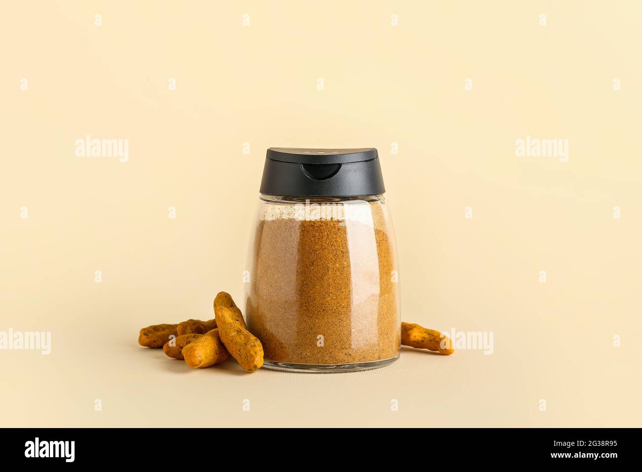 Jar of turmeric powder and roots on color background Stock Photo - Alamy