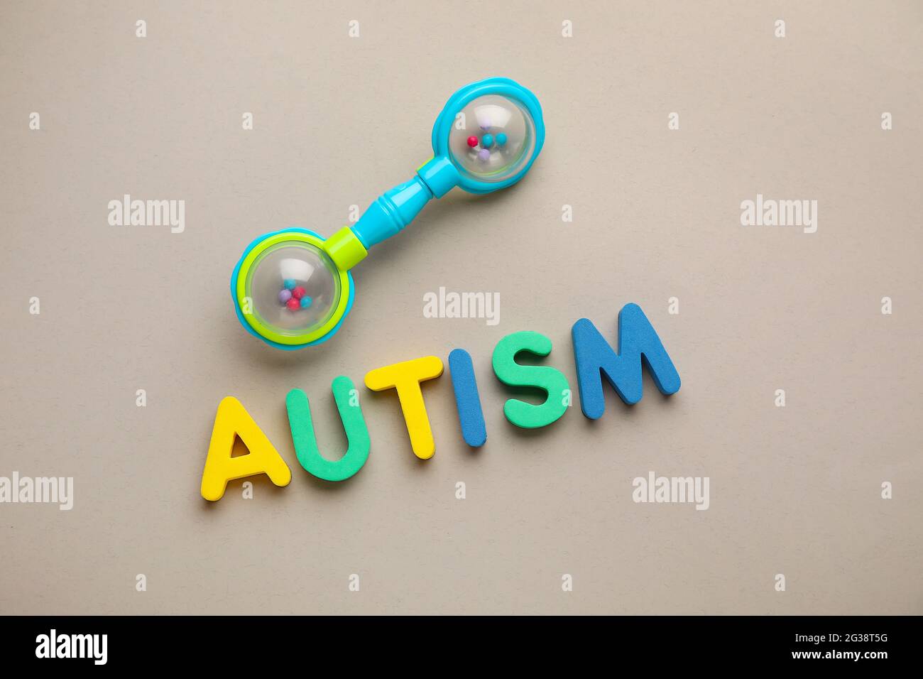 Word AUTISM and rattle on grey background Stock Photo - Alamy