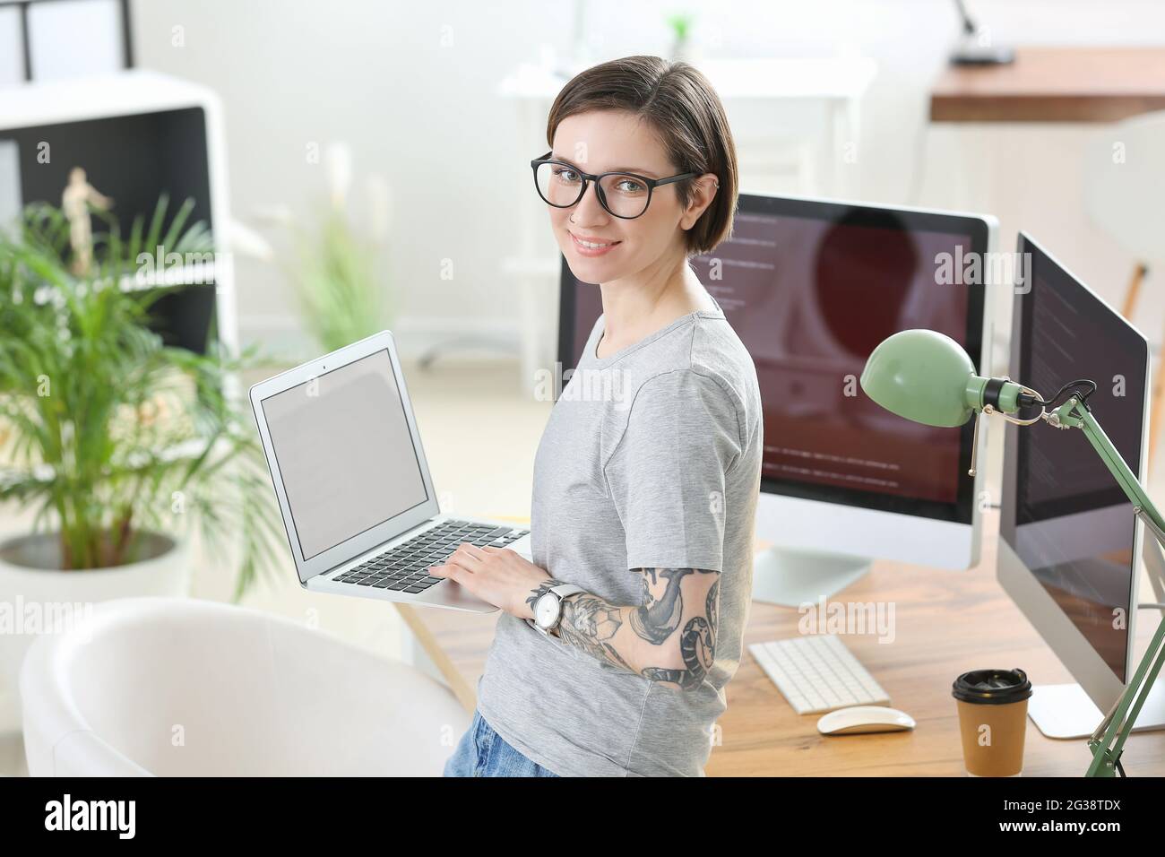 Female programmer working with laptop in office Stock Photo - Alamy