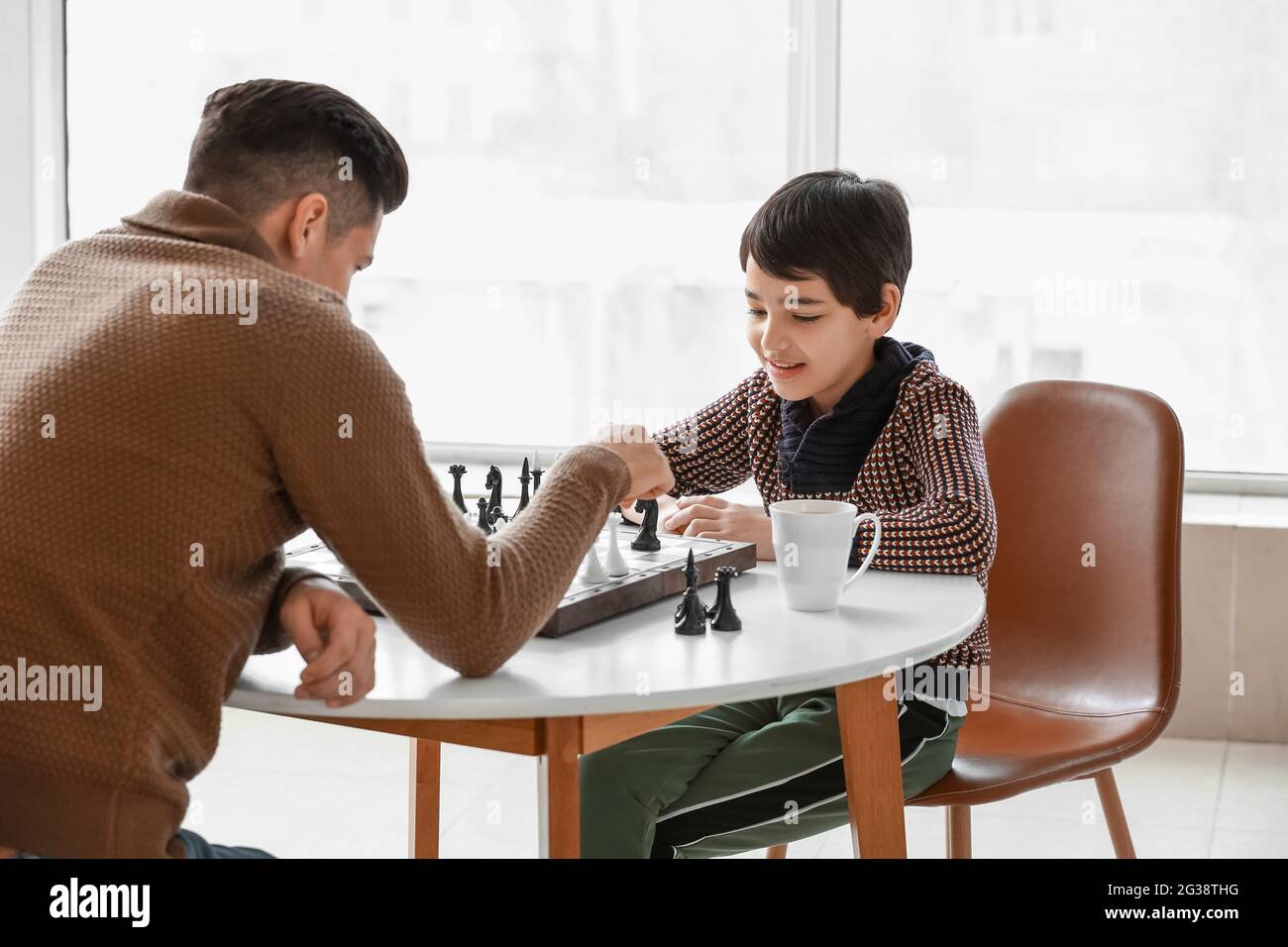 Father and son playing chess at home Stock Photo - Alamy