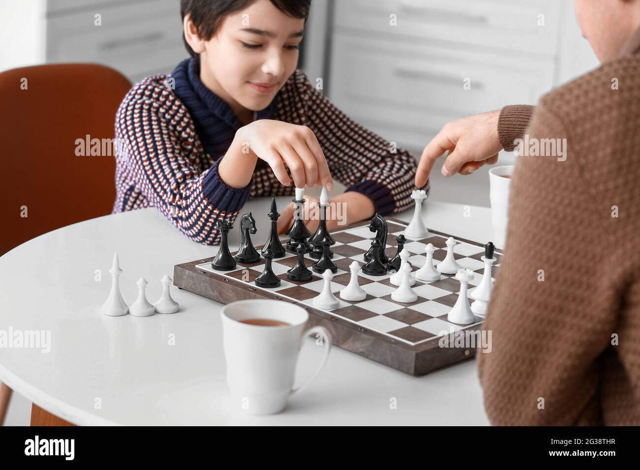 Father and son playing chess at home Stock Photo - Alamy