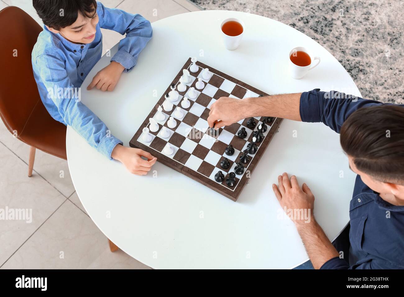 Father and son playing chess at home Stock Photo - Alamy