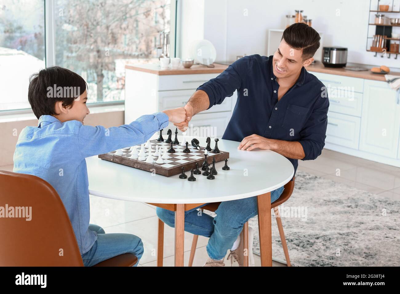 Father and son playing chess in kitchen Stock Photo - Alamy