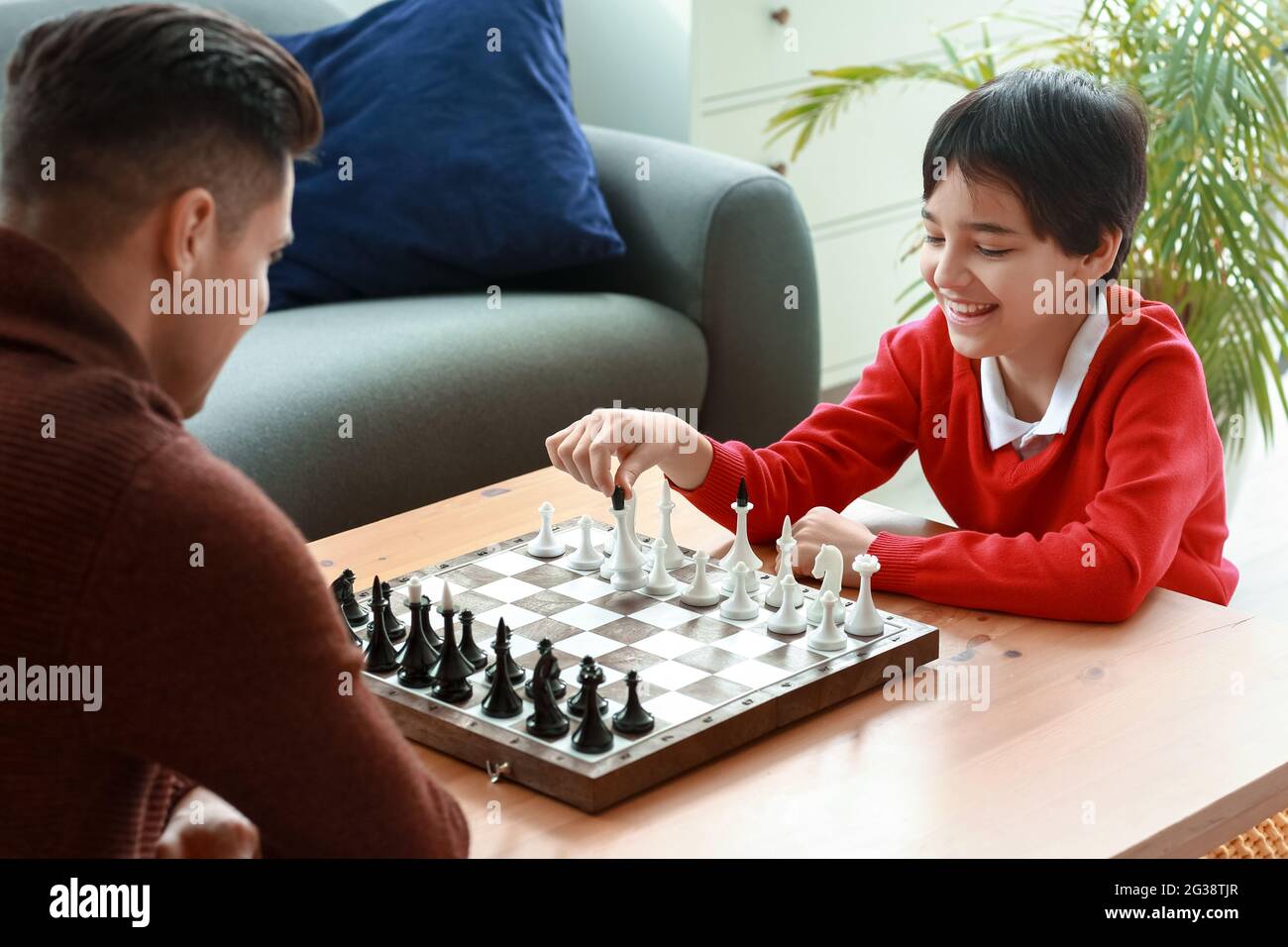 Father and son playing chess at home Stock Photo - Alamy