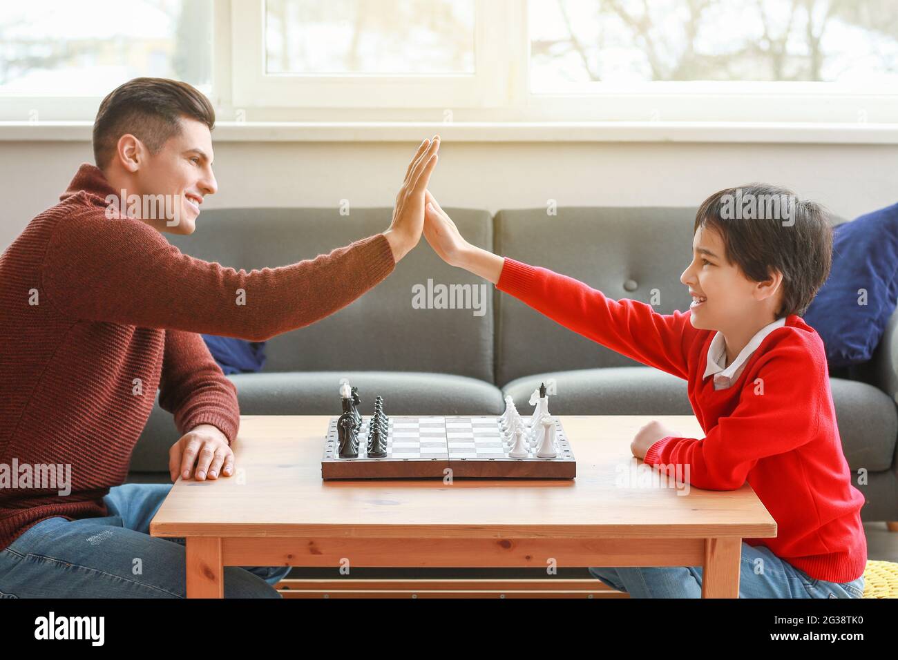 Father and son playing chess at home Stock Photo - Alamy