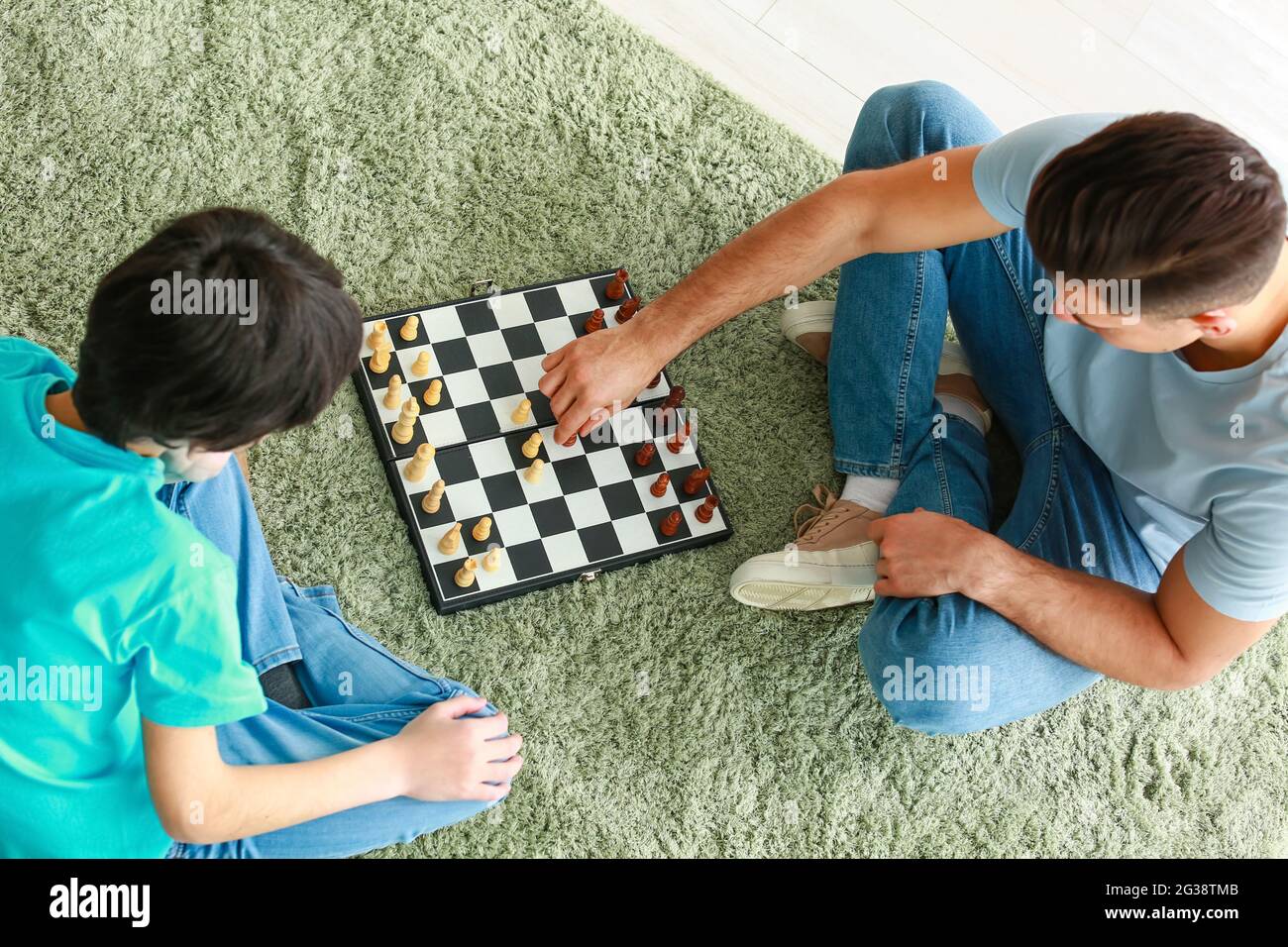 Father and son playing chess at home Stock Photo - Alamy