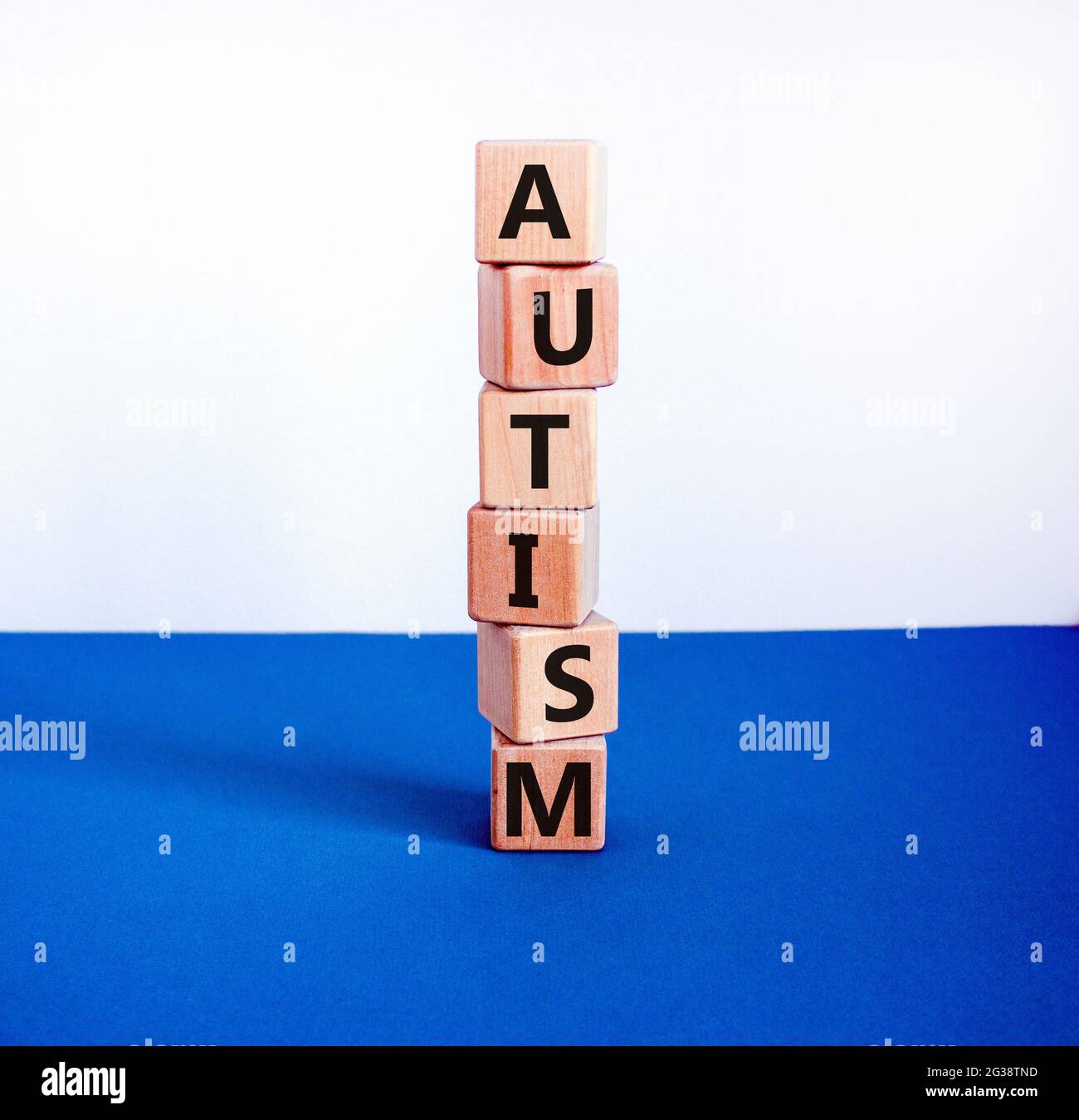 Autism symbol. Wooden cubes with the word 'autism'. Beautiful white and ...