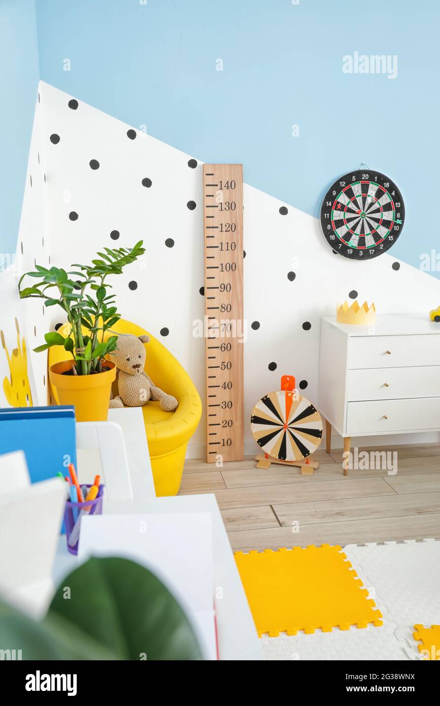 Stylish interior of modern children's room with wooden stadiometer ...
