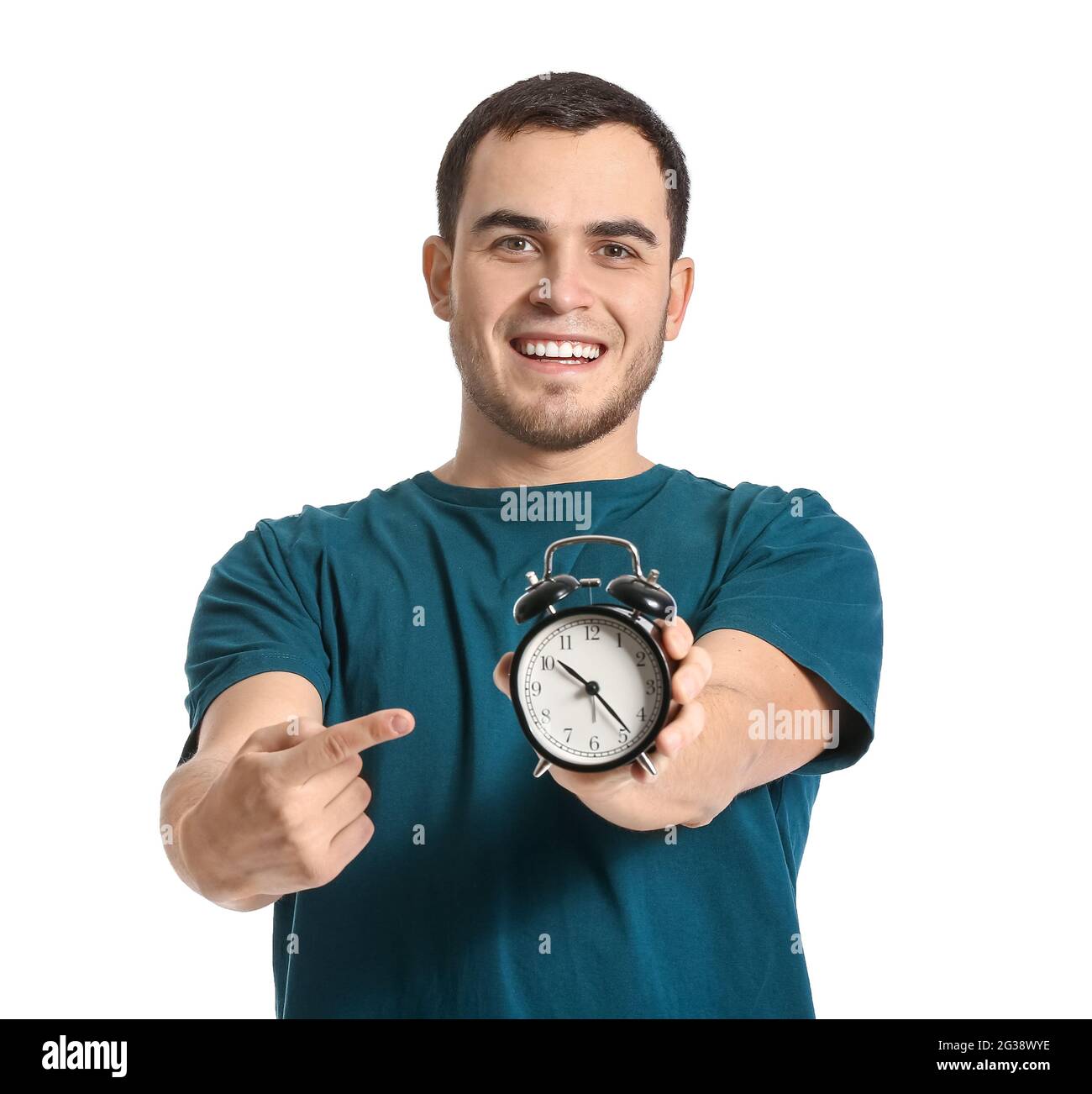 Handsome young man pointing at alarm clock on white background Stock ...