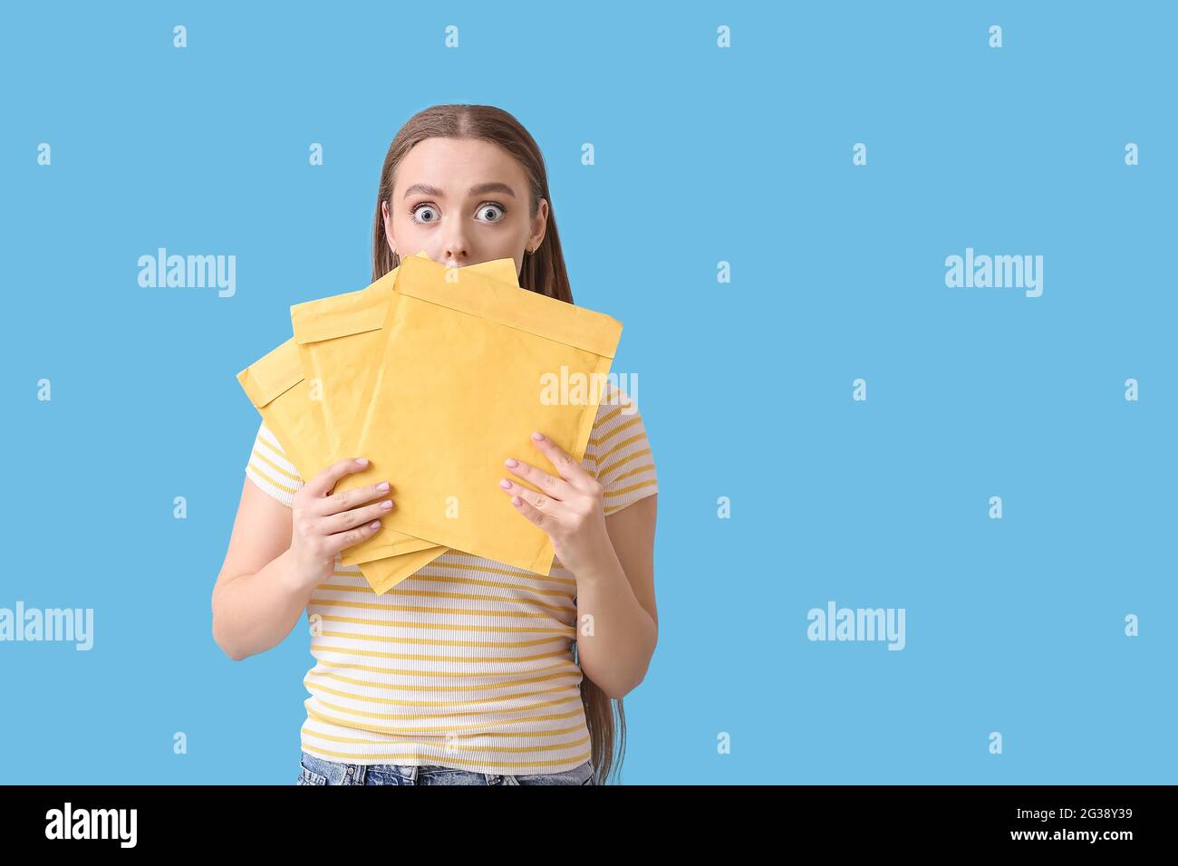 Shocked young woman with letters on color background Stock Photo - Alamy