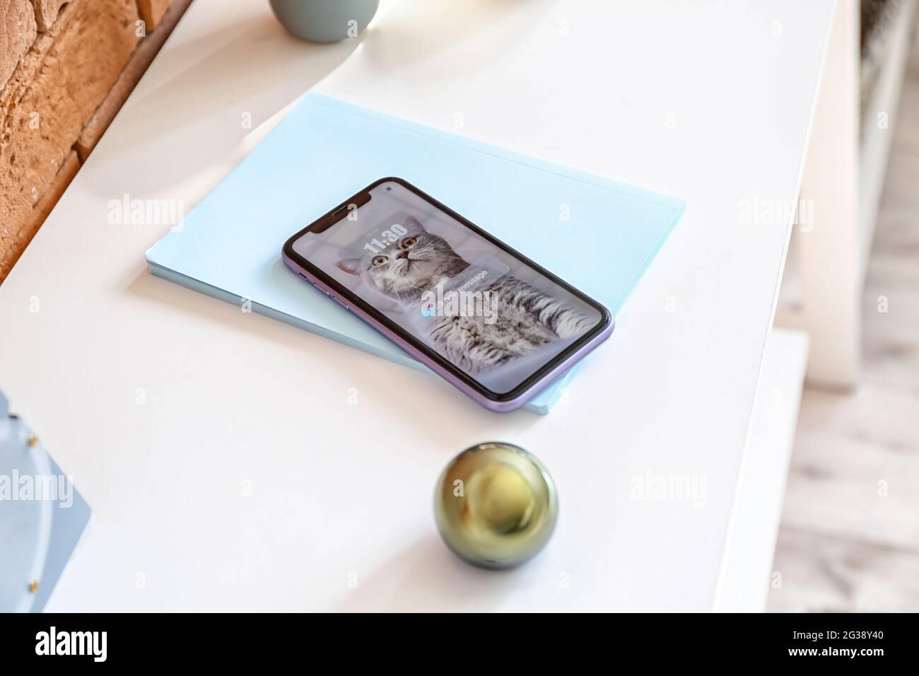 Mobile phone with e-mail notification on screen and notebook on table ...