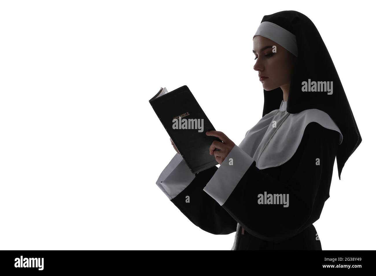 Young praying nun with Bible on white background Stock Photo - Alamy