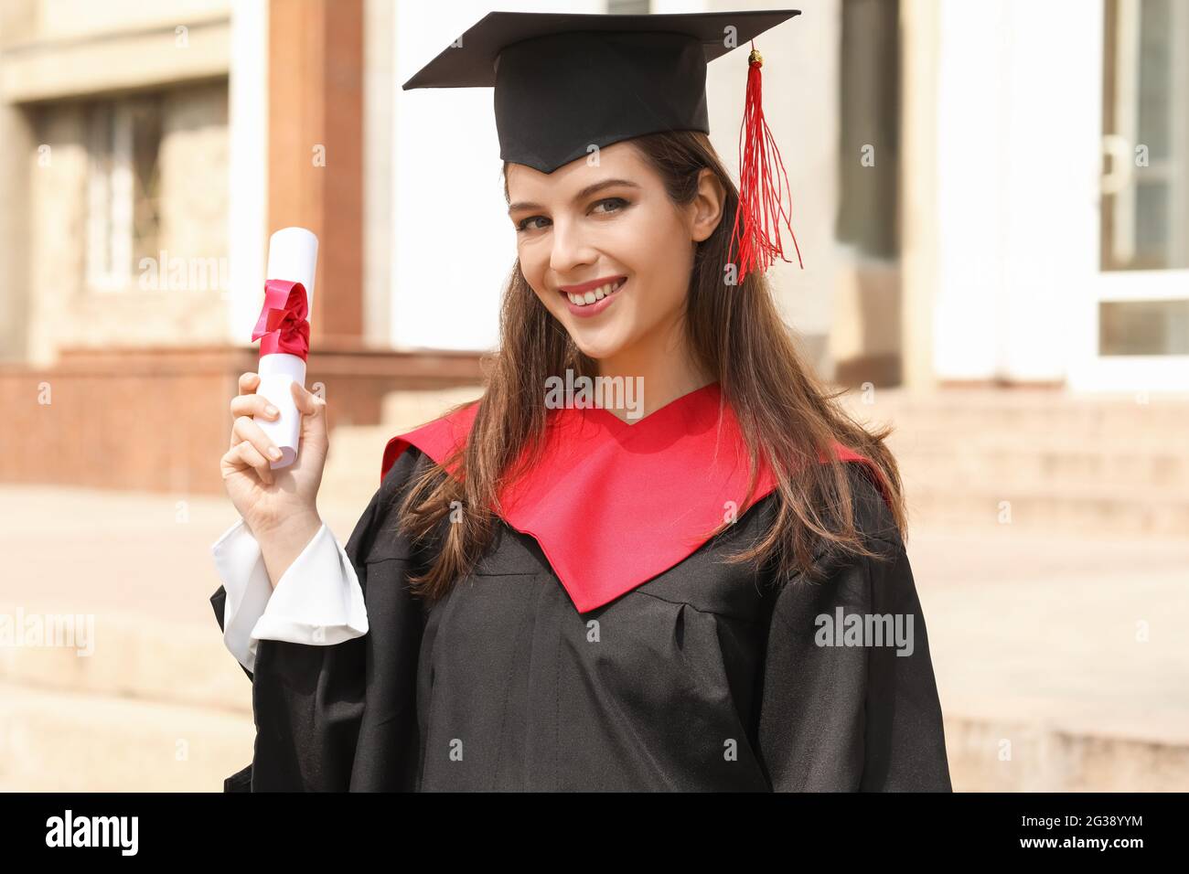 Female student in bachelor robe and with diploma on her graduation day ...