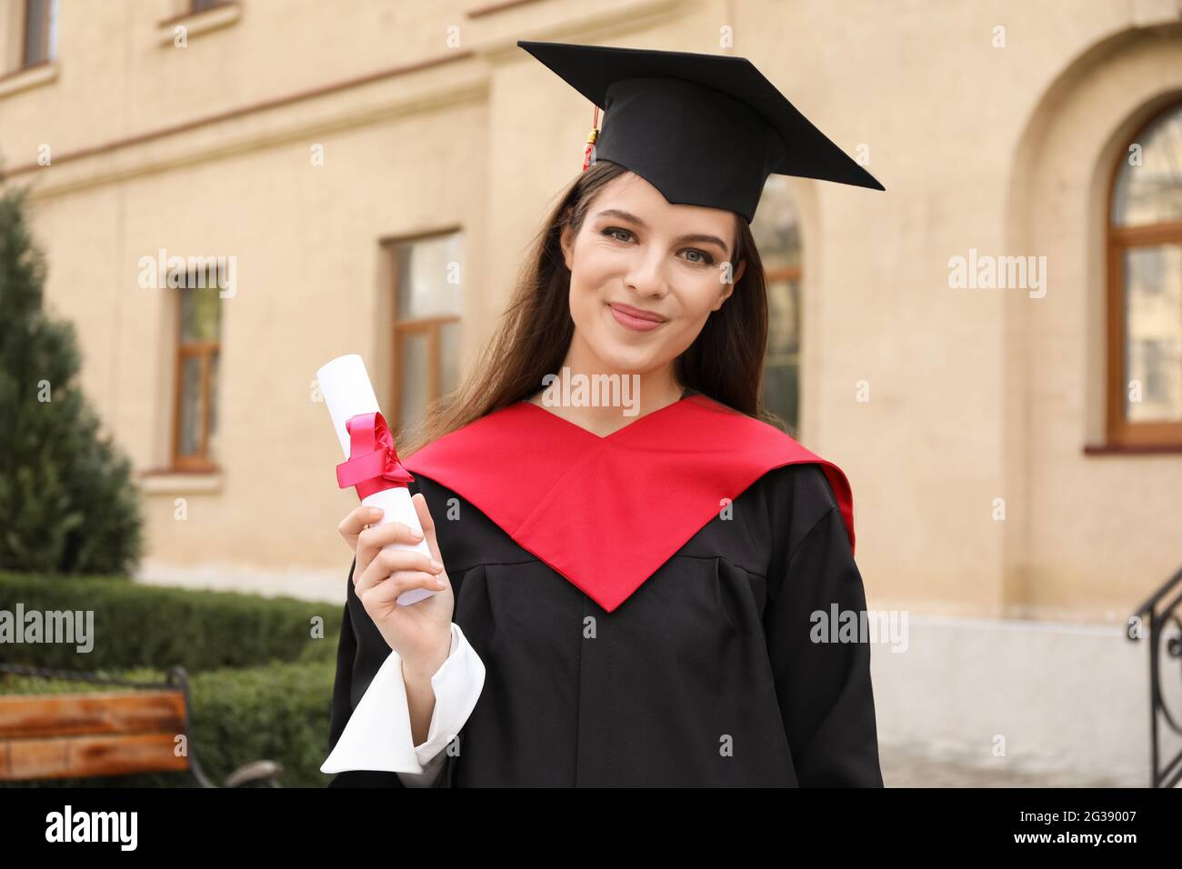 Female student in bachelor robe and with diploma on her graduation day ...