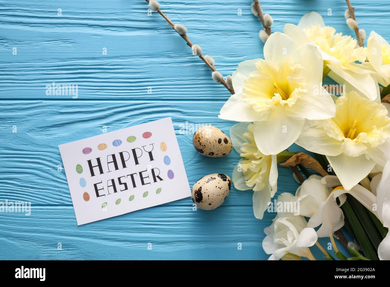 Beautiful flowers, quail eggs and card with text HAPPY EASTER on color ...