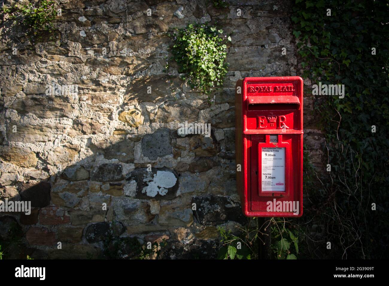 Ever present Royal Mail: a classic red letterbox on a wall in ...