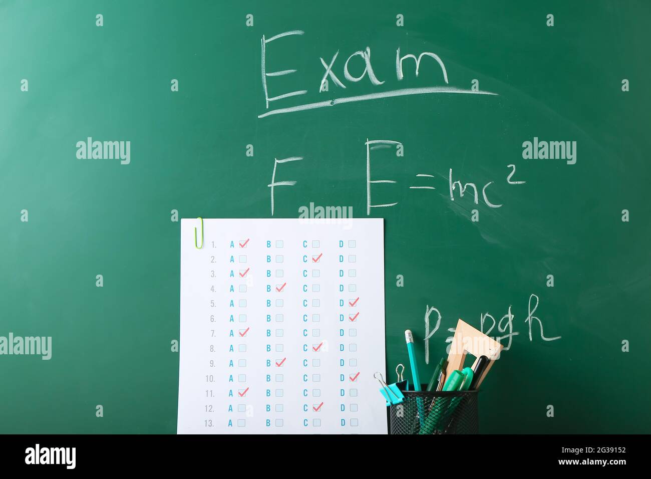Answer sheet and stationery on blackboard Stock Photo - Alamy