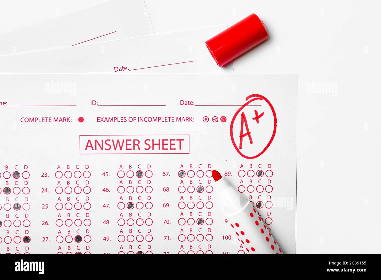 Checked answer sheet and marker on white background, closeup Stock ...