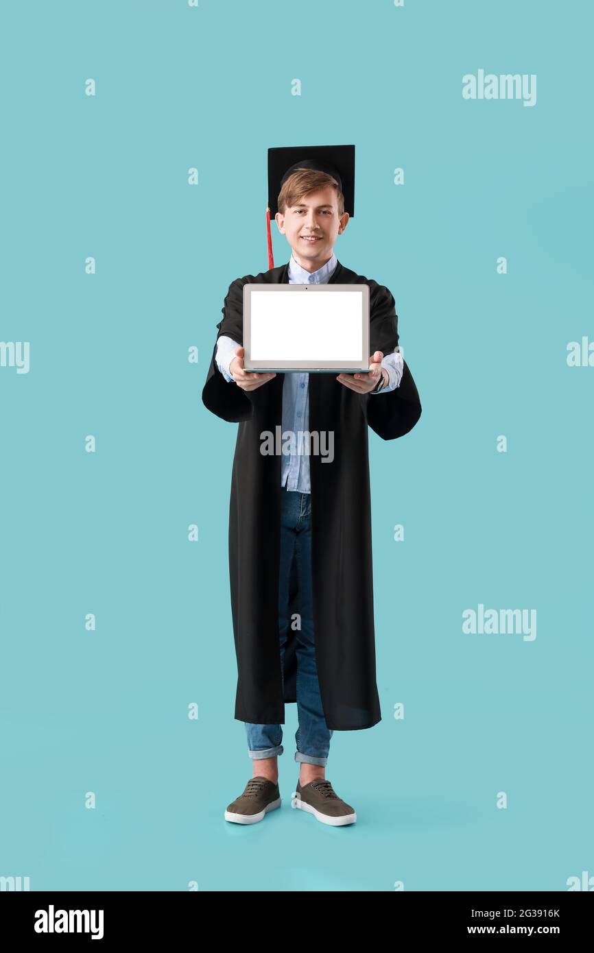 Male graduating student with laptop on color background Stock Photo - Alamy