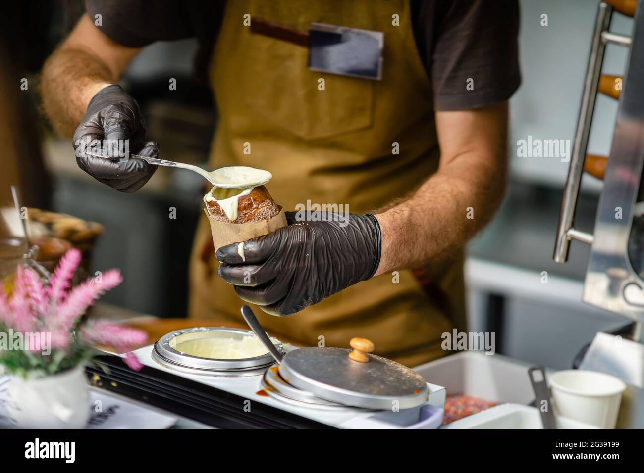 Male Hands of chef making Trdelnik. National street food, cake made out ...