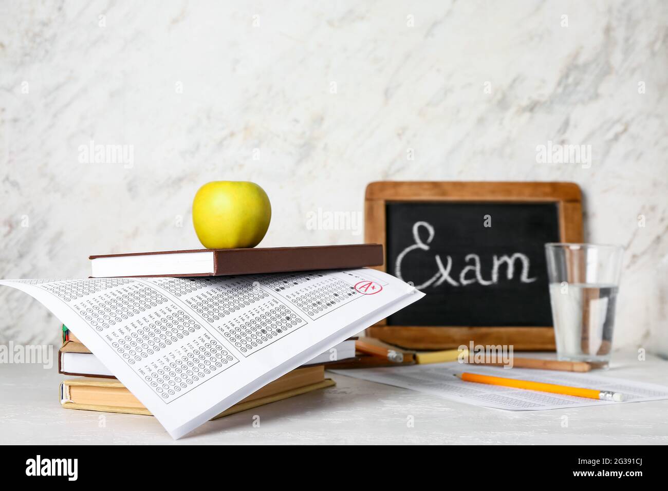 Stack of books and checked answer sheet forms on light background Stock ...