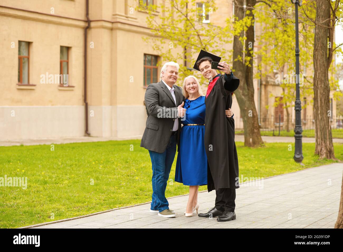 Happy young man with his parents on graduation day Stock Photo - Alamy