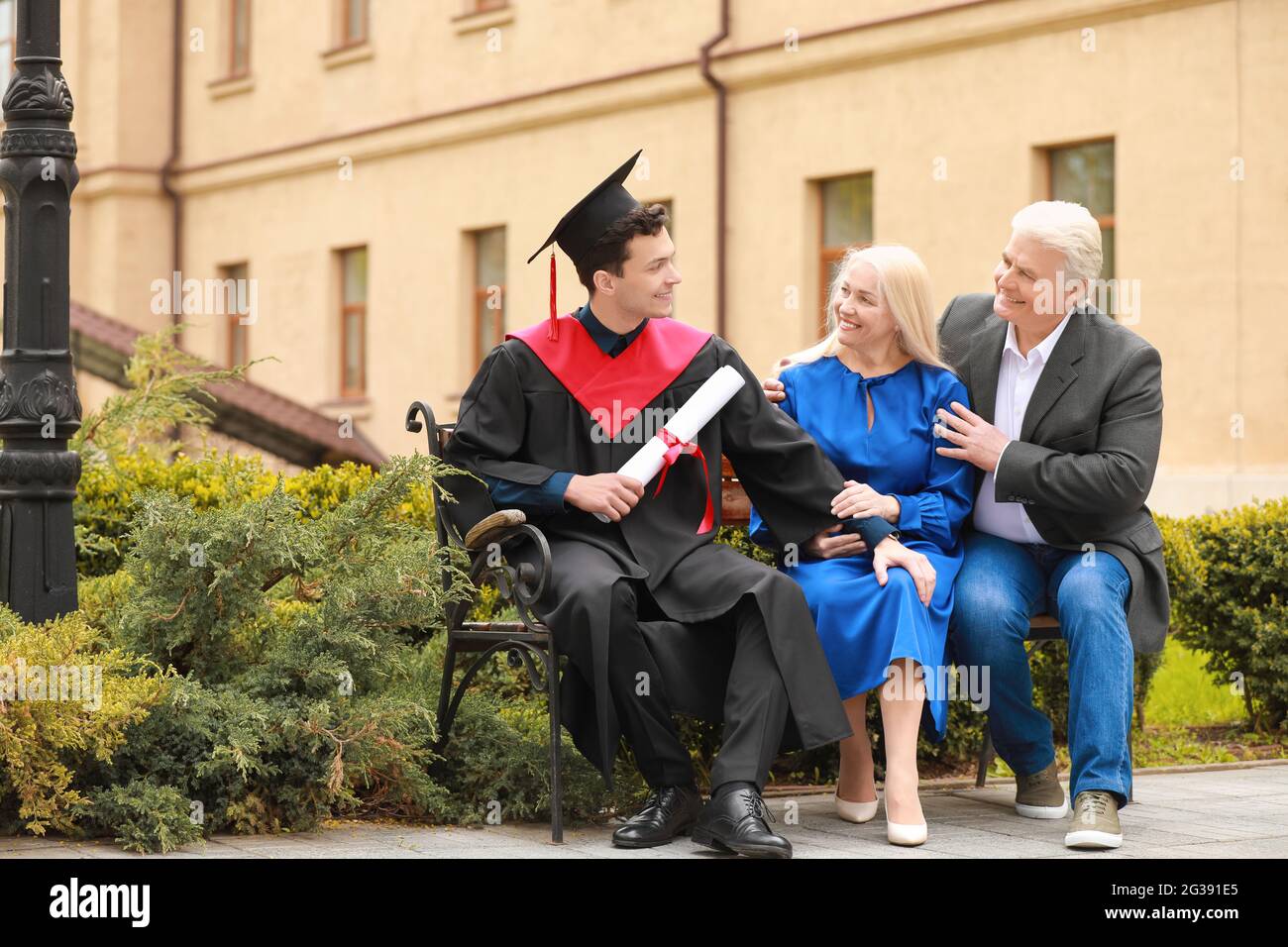 Happy young man with his parents on graduation day Stock Photo - Alamy