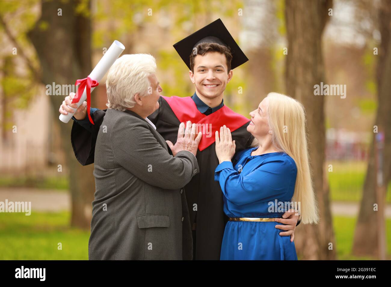 Happy young man with his parents on graduation day Stock Photo - Alamy