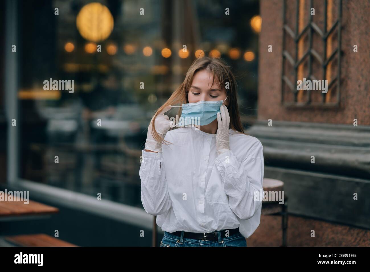 Young caucasian girl takes off her face mask Stock Photo - Alamy